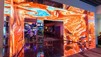 Decoração moderna com piso espelhado e design vibrante e abstrato na parede.