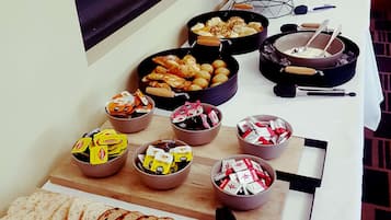 Uma mesa de buffet com diversos alimentos e acompanhamentos.
