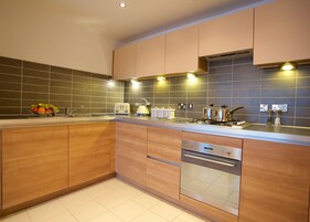 Um frigorífico, um micro-ondas, um forno, uma placa de cozinha 