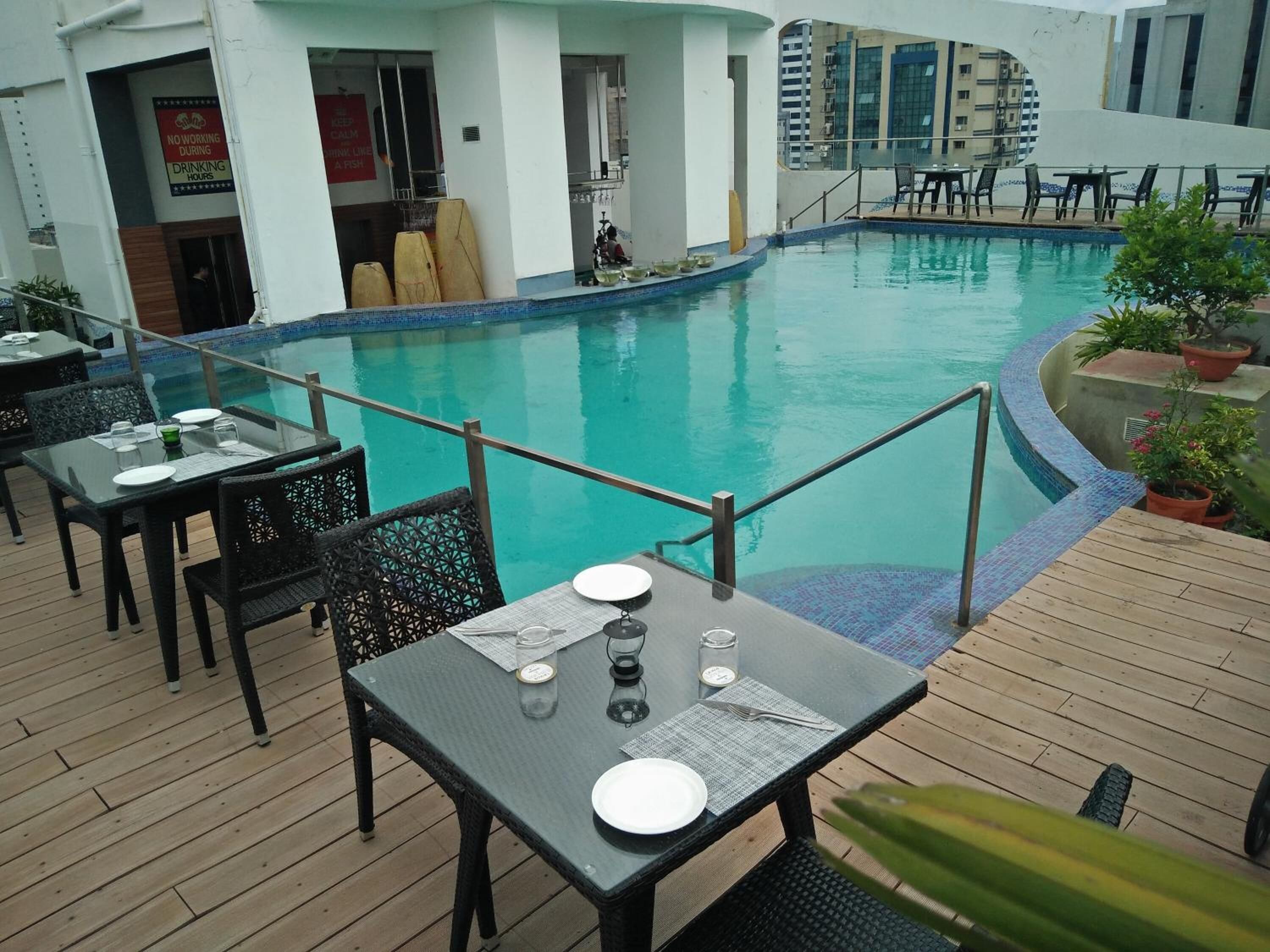 Piscina interior com área de refeições, mesas e cadeiras.