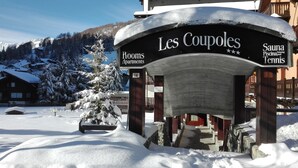 Um edifício coberto de neve com placas indicando 