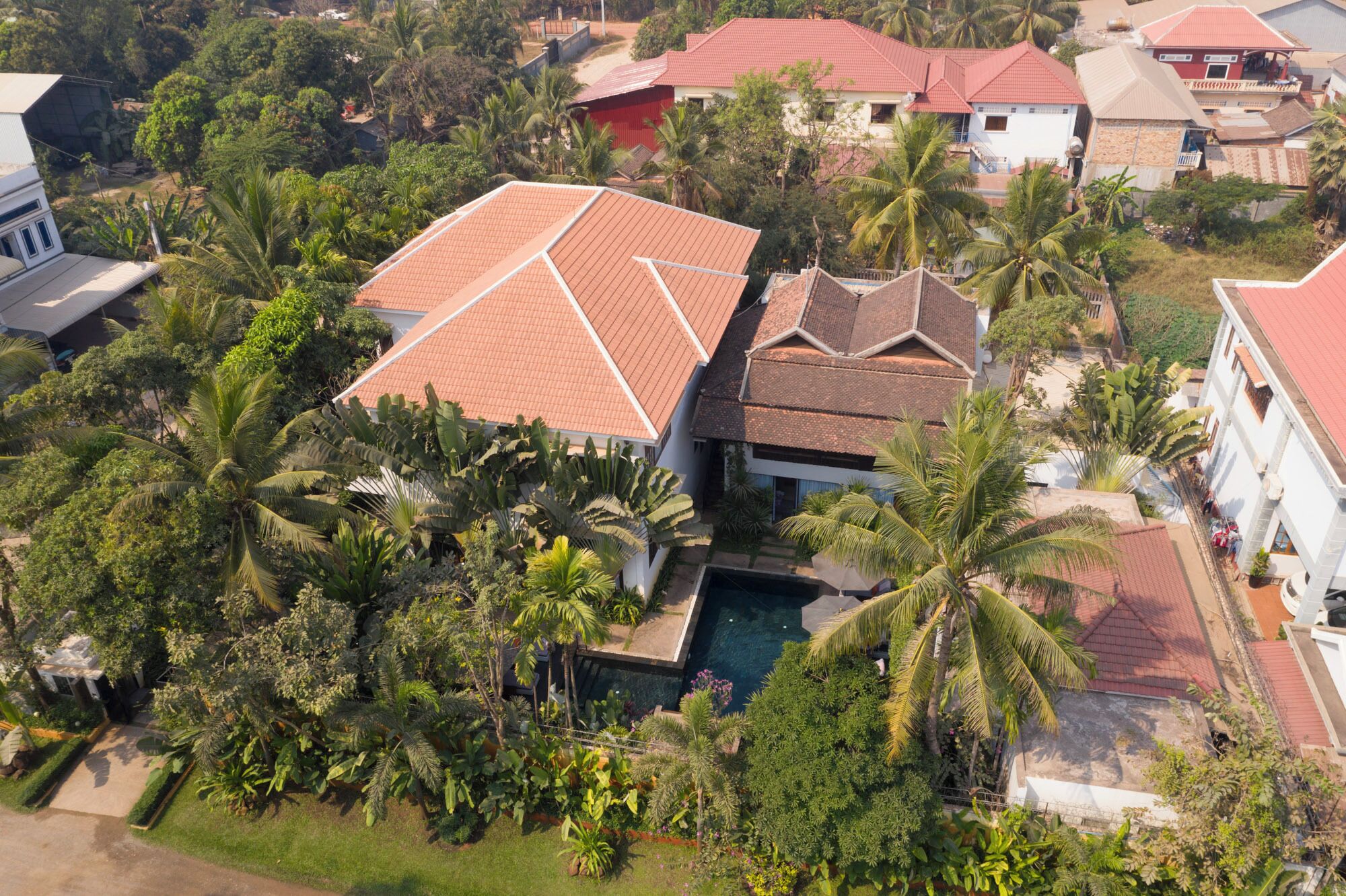 Uma área residencial com casas, piscina e vegetação exuberante.