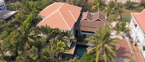 Uma área residencial com casas, piscina e vegetação exuberante.
