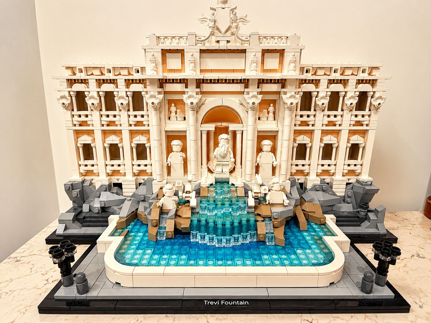 Uma réplica LEGO da Fontana di Trevi, com uma estátua central, várias arcadas e um tanque ao redor.