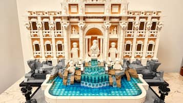 Uma réplica LEGO da Fontana di Trevi, com uma estátua central, várias arcadas e um tanque ao redor.