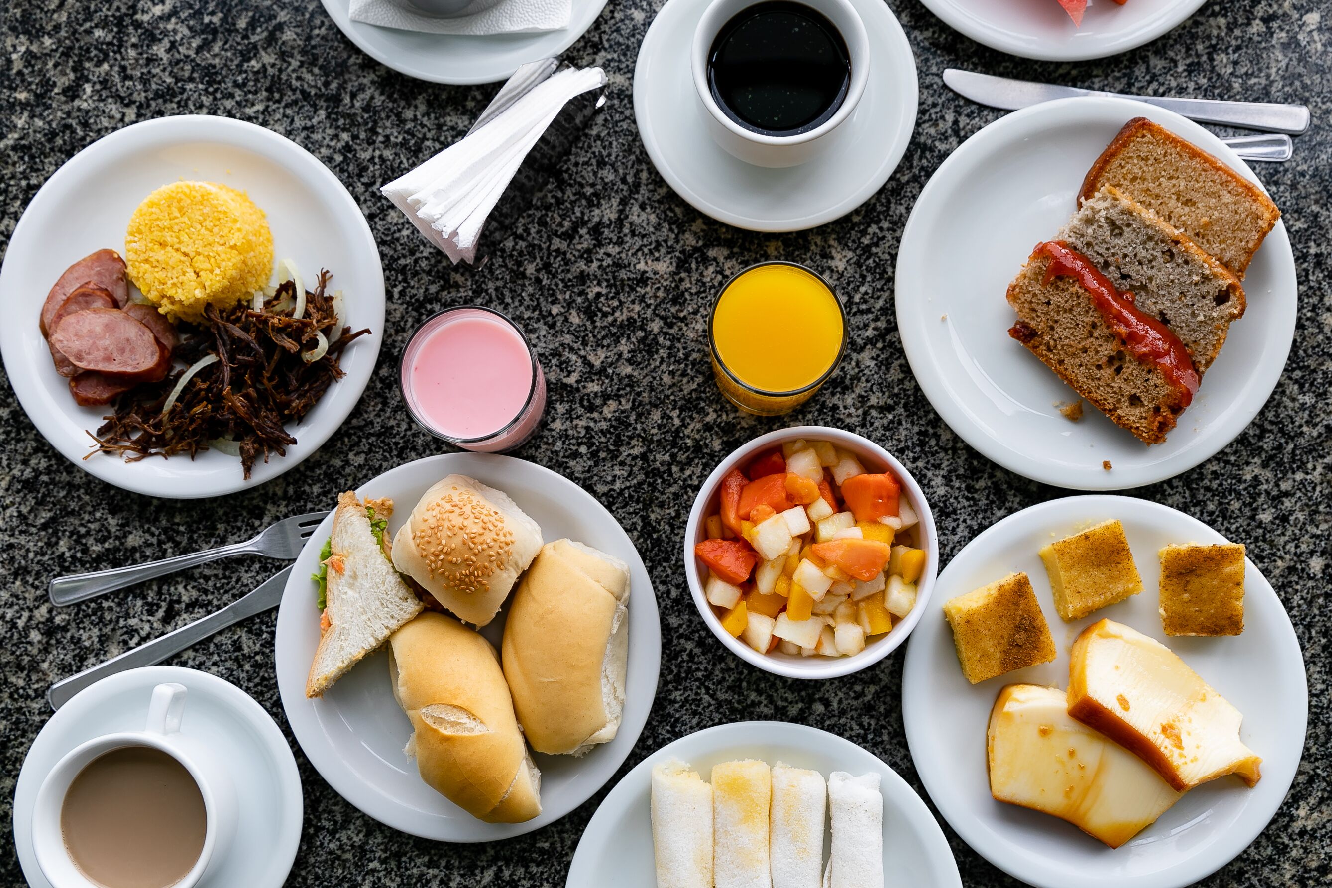 Uma mesa de café da manhã com diversos pratos e bebidas.