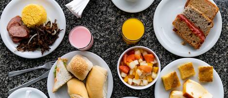 Uma mesa de café da manhã com diversos pratos e bebidas.