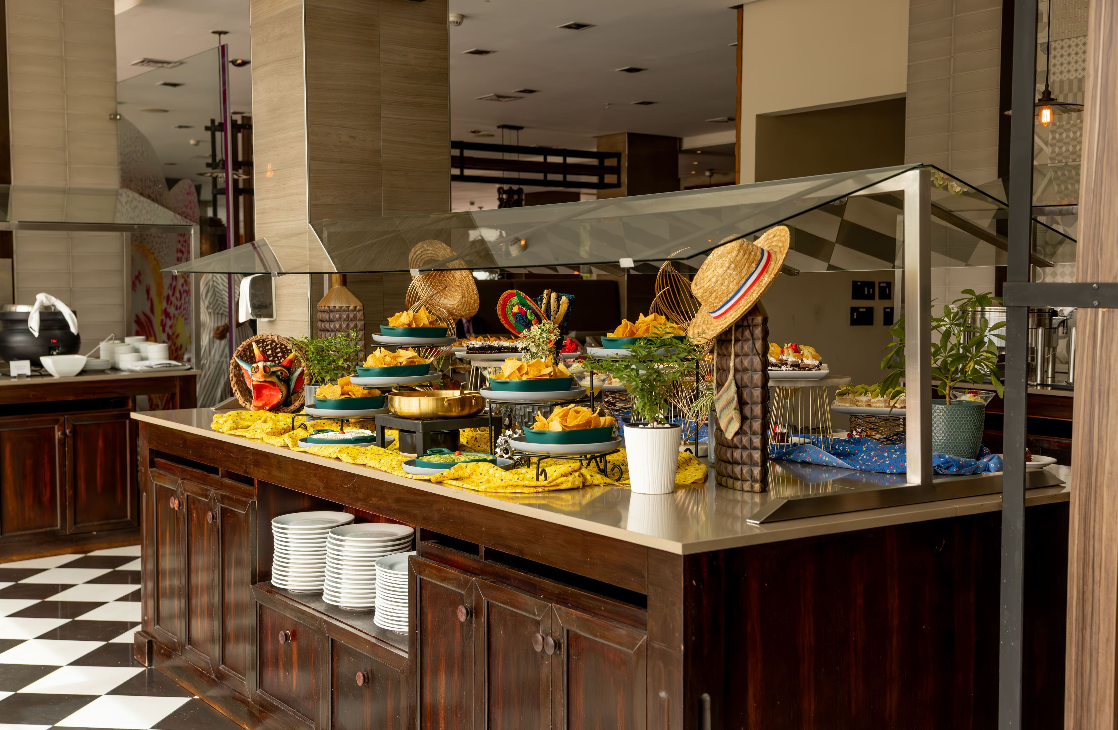 Disposição de buffet com diversos alimentos e um chapéu decorativo.