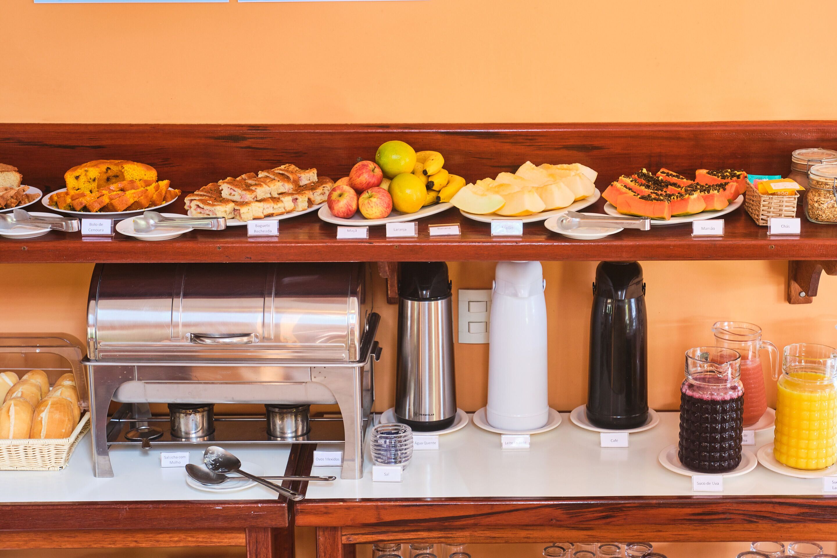 Um buffet com diversos alimentos e máquinas de café.
