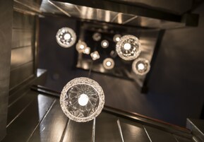 Um candelabro com várias luminárias em um espaço interior moderno.