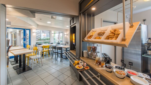 Uma sala de café da manhã moderna com serviço de buffet, incluindo diversos alimentos e bebidas.