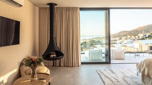 Quarto de hotel moderno com uma grande porta de vidro deslizante que dá para uma varanda com vista para a cidade.