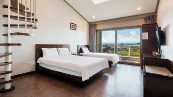 Quarto de hotel com duas camas, uma janela grande com vista, televisão e escada.