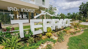 Placa para 'The Terrace', com um edifício moderno ao fundo.