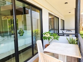 Uma varanda com mesa, cadeiras e plantas em vasos.