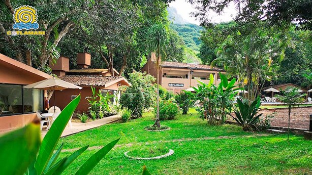 Um jardim com um canteiro circular, um edifício com a placa 