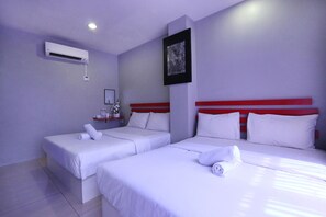 Quarto de hotel com duas camas, cabeceira vermelha, roupa de cama branca, ar condicionado e um quadro na parede.