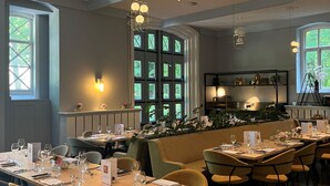 Restaurante com várias mesas, cadeiras e um espaço de bar.
