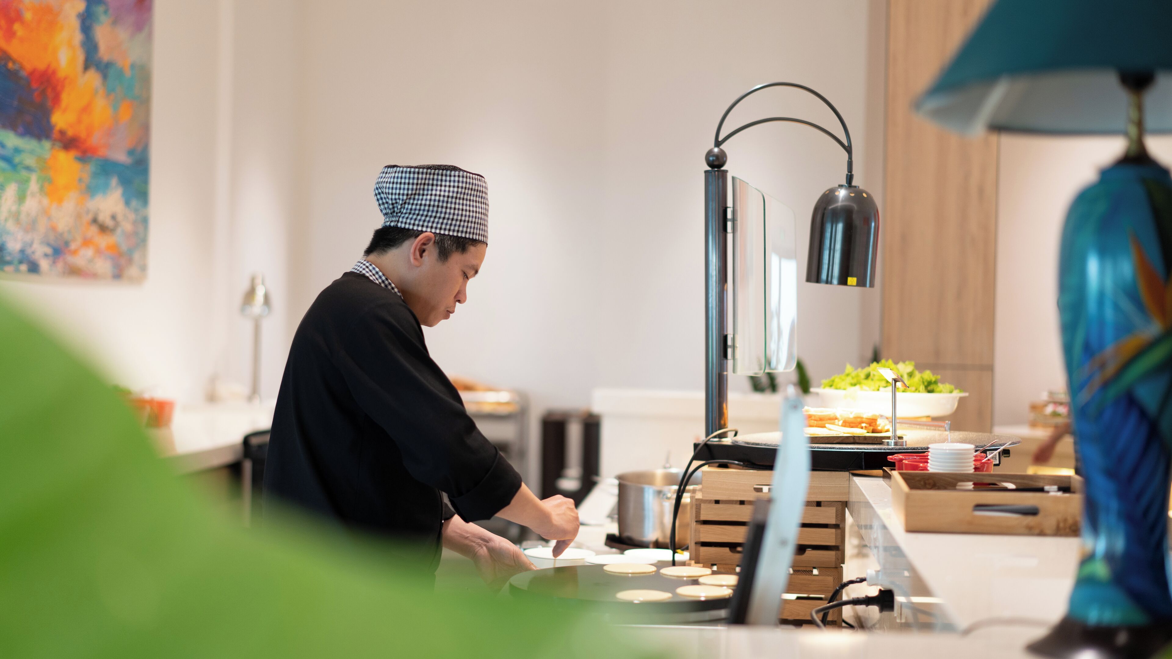 Uma pessoa preparando comida em uma cozinha moderna com serviço de buffet.