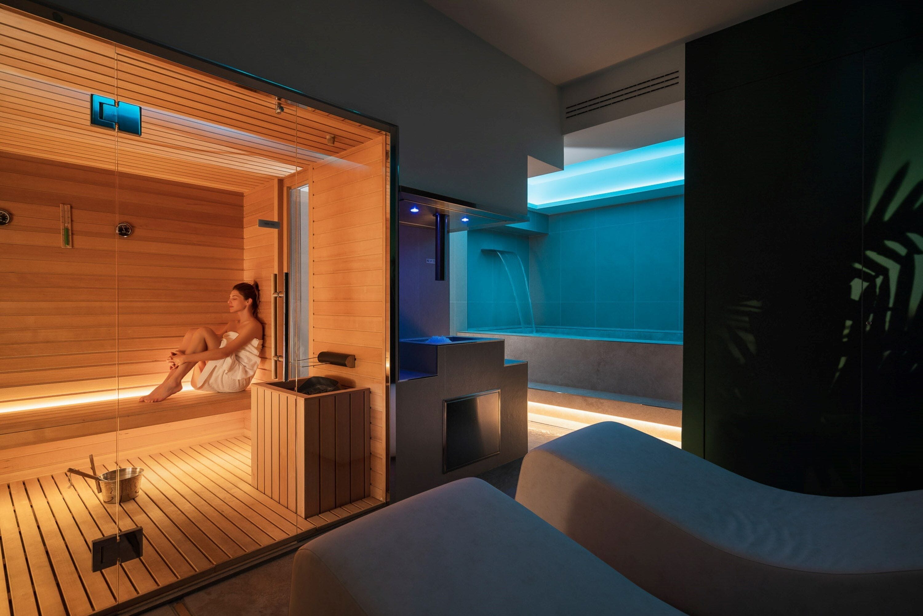 Uma sauna moderna com paredes de madeira, um banco e uma mesa de massagem.