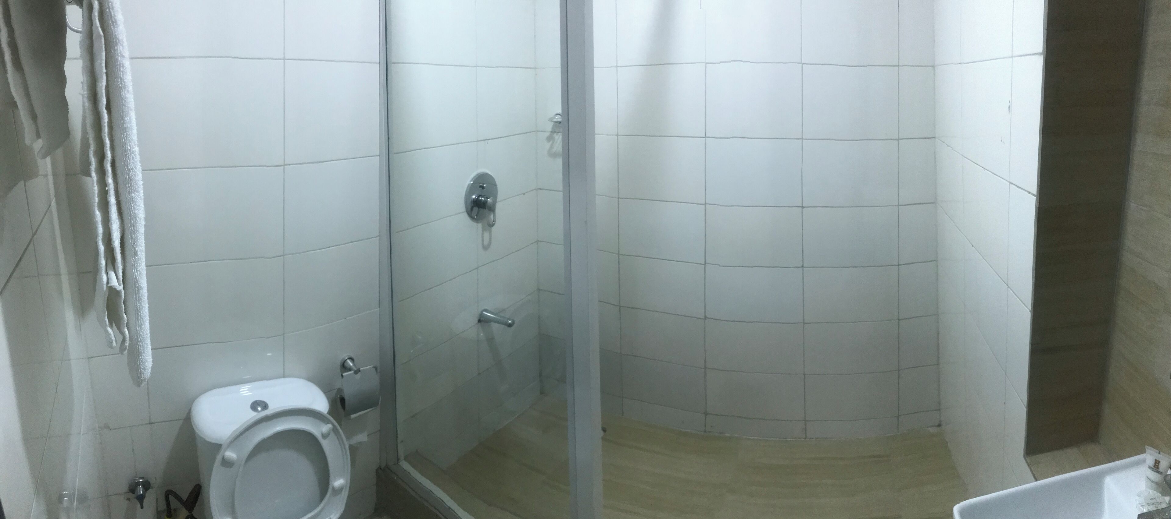 Casa de banho com sanita, cabine de duche e lavatório.