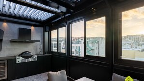Uma cozinha moderna com fogão embutido, uma janela grande com vista para a cidade e um claraboia.