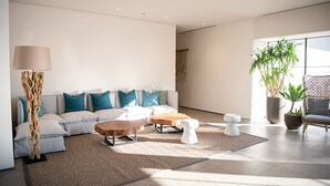 Uma sala de estar moderna com sofá, mesa de centro, mesa lateral e abajur.