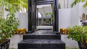 Entrada de um hotel moderno com uma escadaria preta que leva a uma área de recepção.