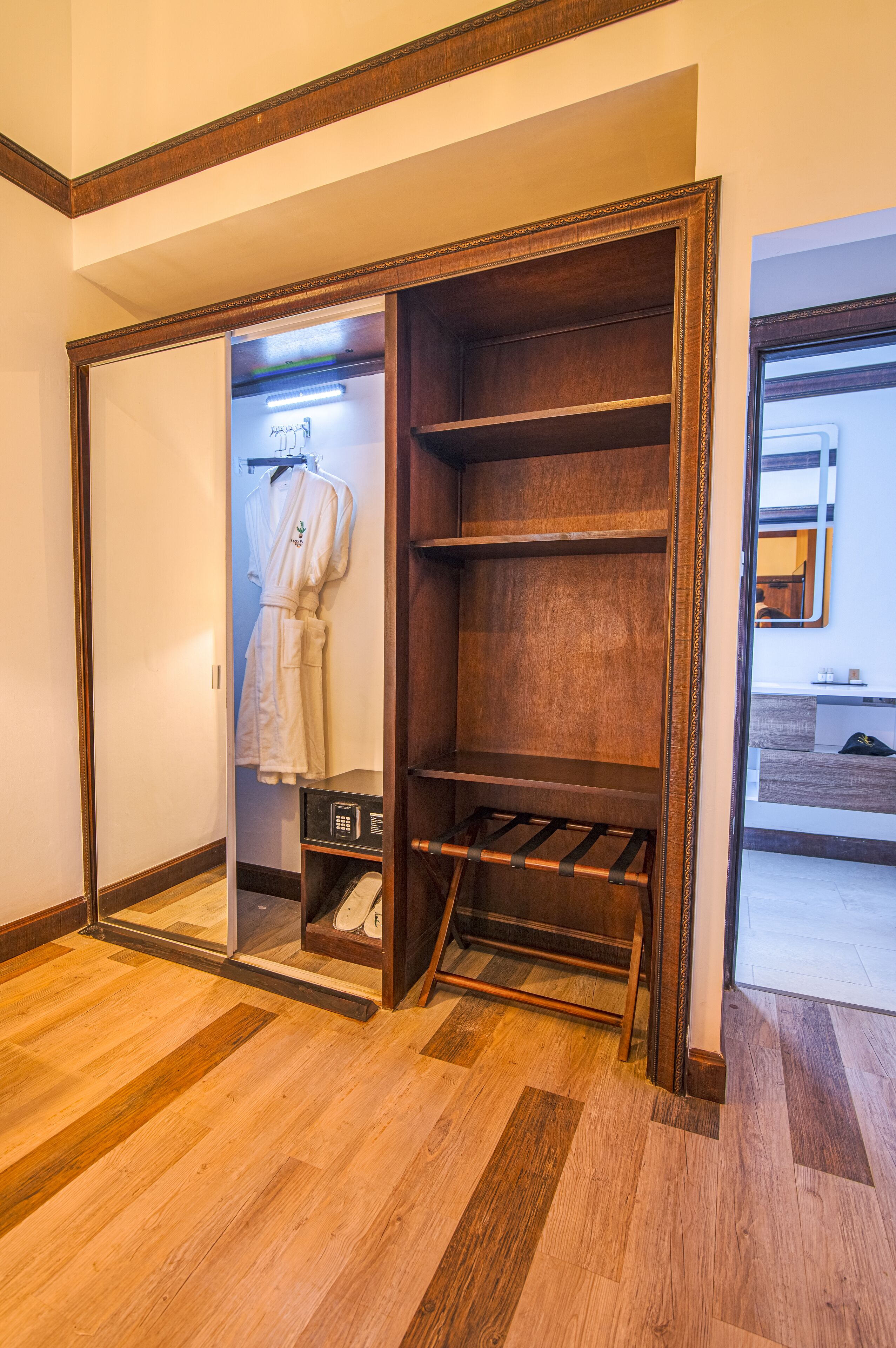 Um closet espaçoso com prateleiras de madeira, um roupão pendurado e um sapateiro.