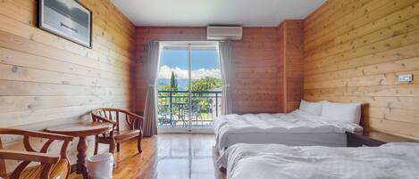 Quarto com painéis de madeira, duas camas, uma mesa e cadeiras.