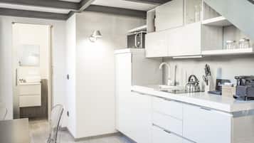 Um frigorífico, uma placa de cozinha, uma máquina de café expresso