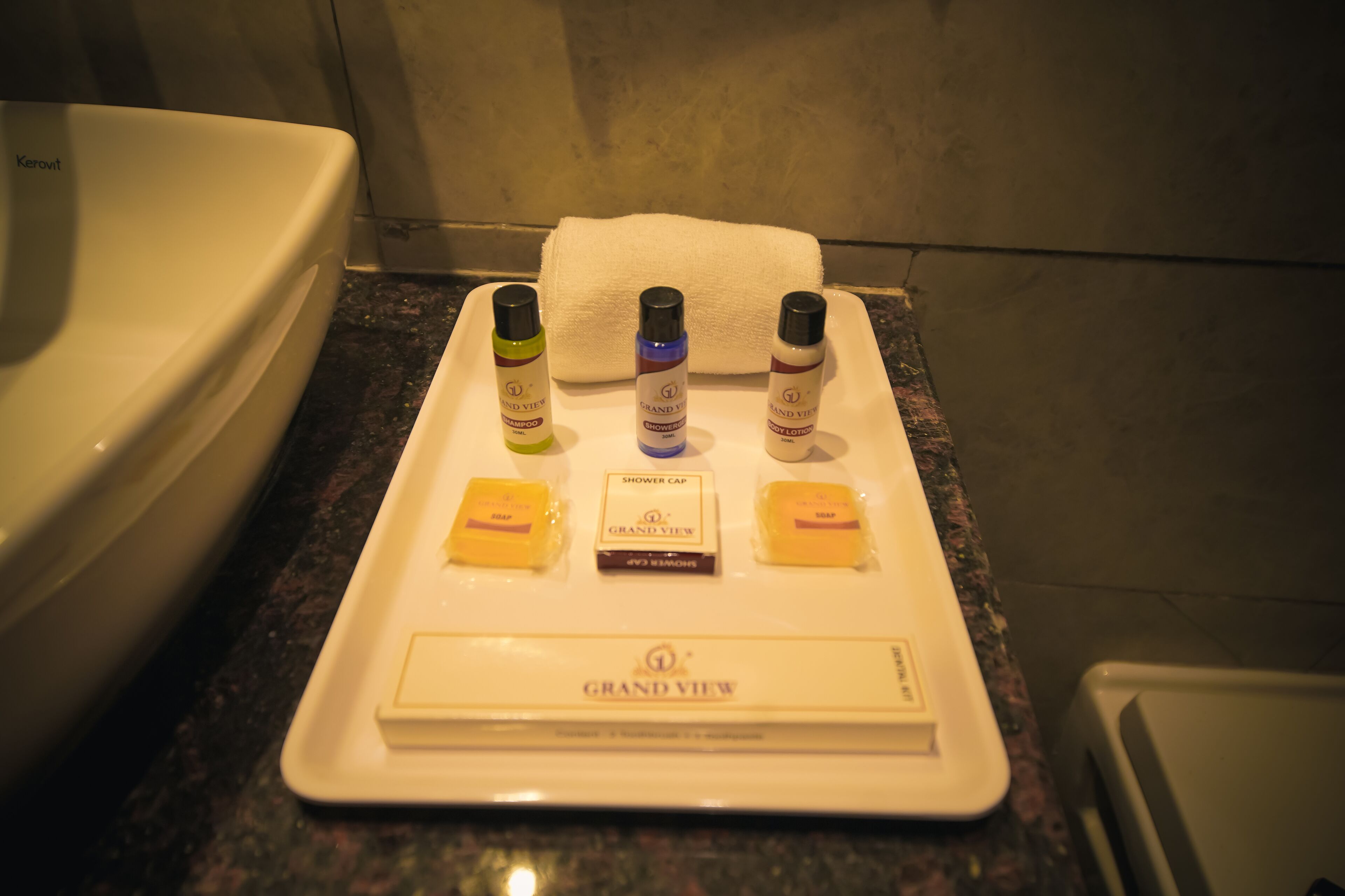 Uma bancada de banheiro com artigos de higiene pessoal, incluindo shampoo, gel de banho e sabonete.
