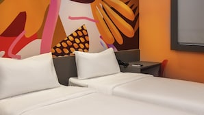 Quarto de hotel com duas camas, mesa de cabeceira, telefone e cadeira.