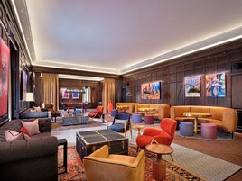 Um hall amplo com várias áreas de estar, mesa de bilhar e obras de arte nas paredes.