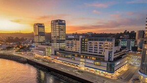 Um hotel moderno com vários andares, vista para a orla e um grande letreiro Novotel.