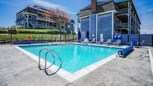 Piscina com espreguiçadeiras e posto de salva-vidas.