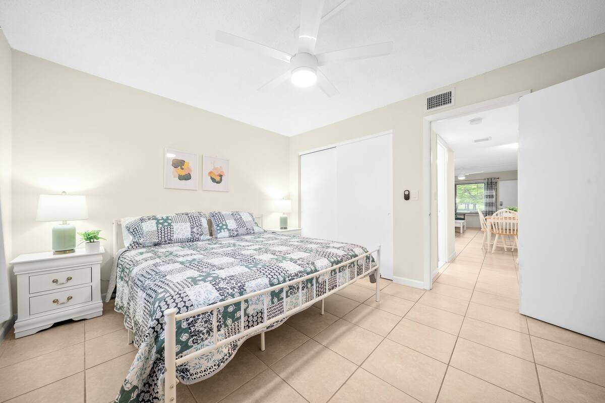Quarto com cama, mesa de cabeceira e decoração na parede.