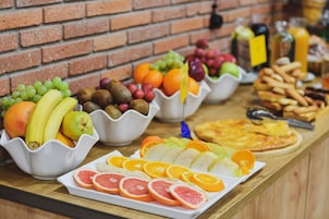 Um buffet de café da manhã com diversas frutas e doces.