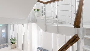 Um interior moderno com escada em espiral, área de estar e planta em vaso.