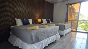 Quarto de hotel moderno com duas camas, uma parede de madeira e uma grande janela com vista para o verde.