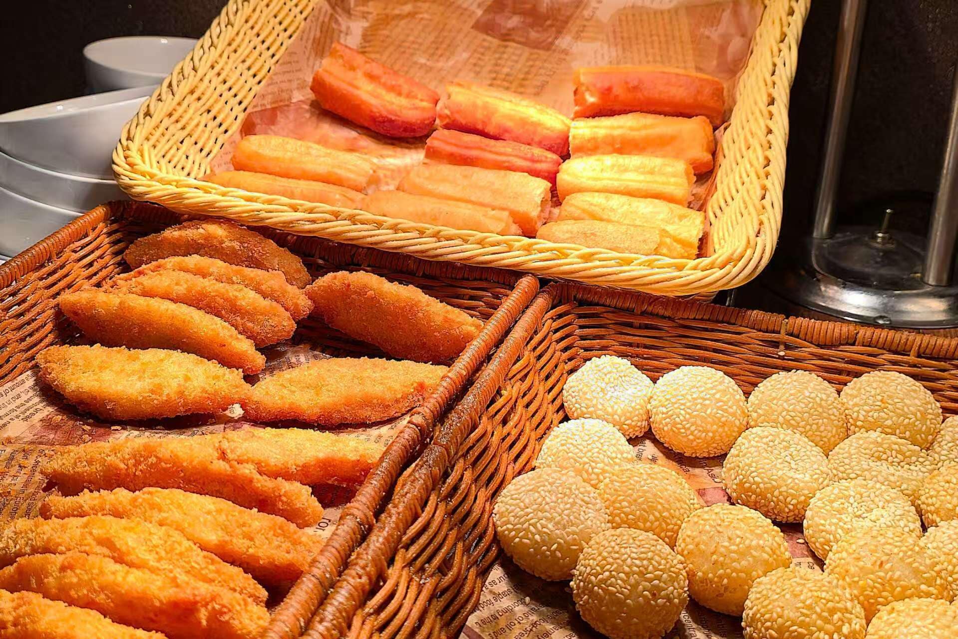 Diversos salgadinhos fritos em cestos de vime.