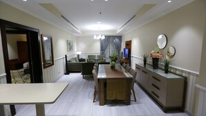 Uma sala de jantar com uma mesa comprida, assentos acolchoados e um balcão de buffet.