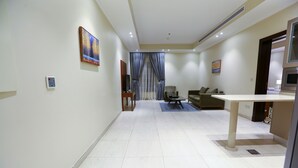 Quarto de hotel moderno com uma cama grande, uma escrivaninha, uma cadeira e uma televisão.