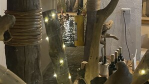 Um espaço interior com pouca luz, com um recurso de água, estruturas de madeira e uma placa indicando um extintor.