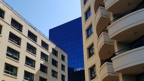 Um edifício moderno com vários andares, janelas amplas e uma área de varanda.