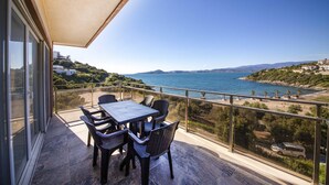Varanda com mesa e cadeiras com vista para a costa.