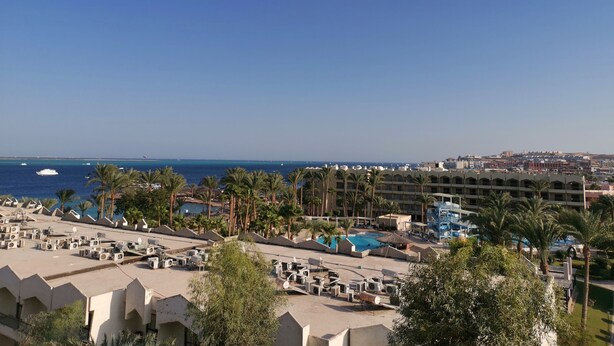 Um resort com vários edifícios, piscina e vista para o mar.