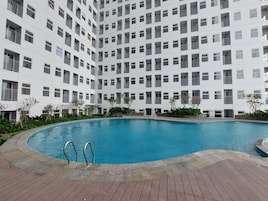 Um edifício moderno com uma piscina central rodeada por um deck de madeira.