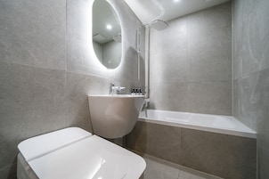 Quarto Twin Familiar | Casa de banho | Uma combinação polibã/banheira, um secador de cabelo, roupões, chinelos