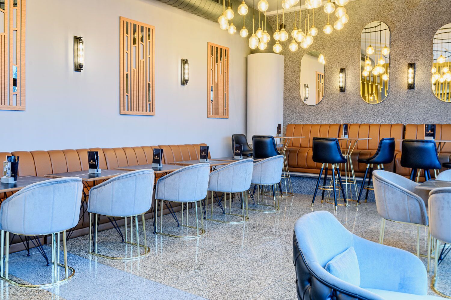 Um restaurante moderno com um balcão comprido, cabines e uma variedade de opções de assento.